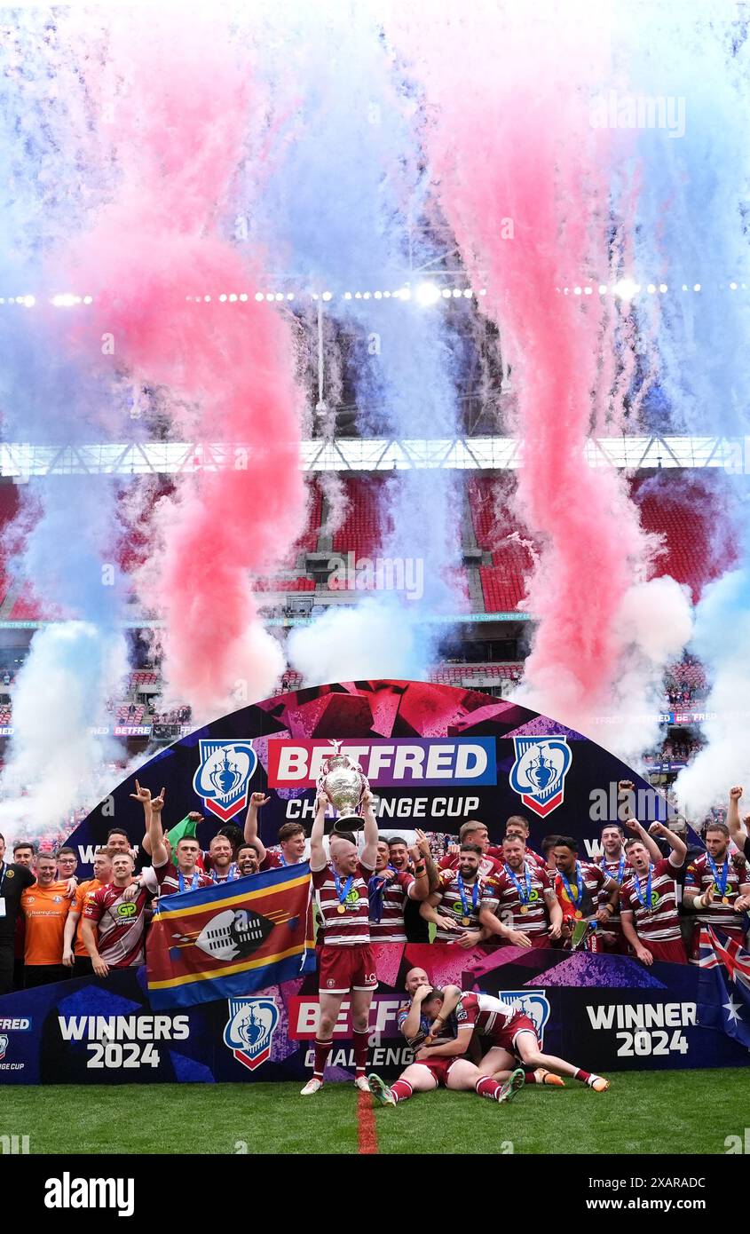 Wigan Warriors' Liam Farrell (centre) lifts the trophy with team-mates ...