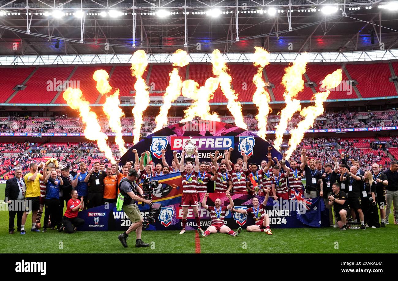 Wigan Warriors' Liam Farrell (centre) lifts the trophy with team-mates ...