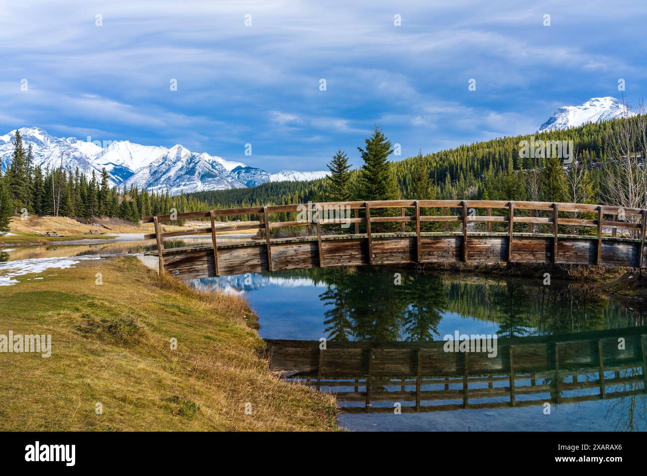 Wooden arch footbridge in Cascade Ponds park in autumn sunny day, snow ...