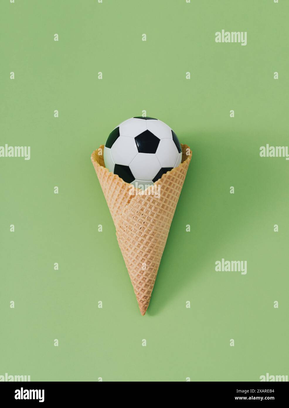 Ice cream cone with football or soccer ball on pastel green background ...
