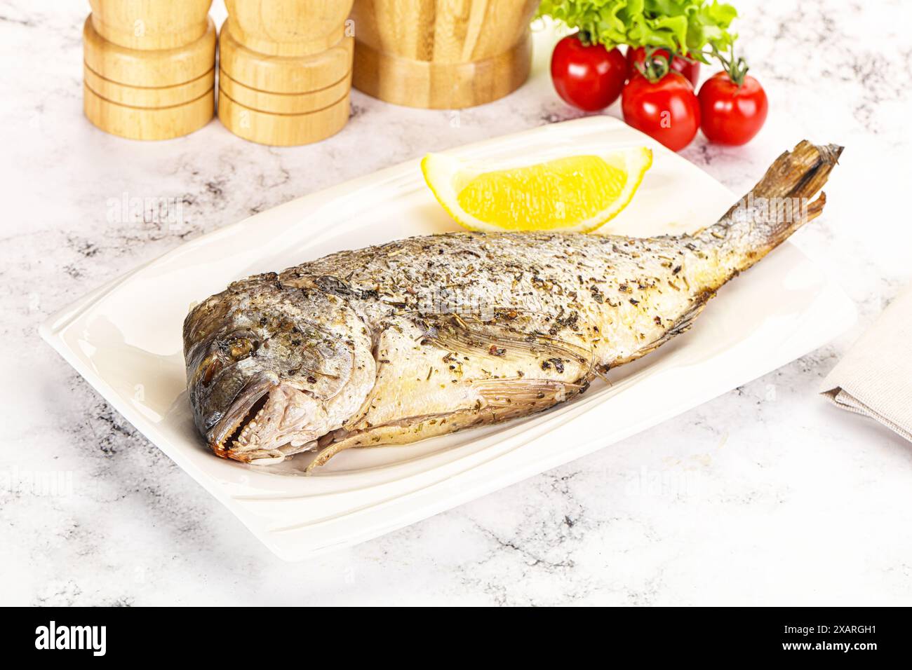 Baked Dorado fish served lemon slice Stock Photo - Alamy