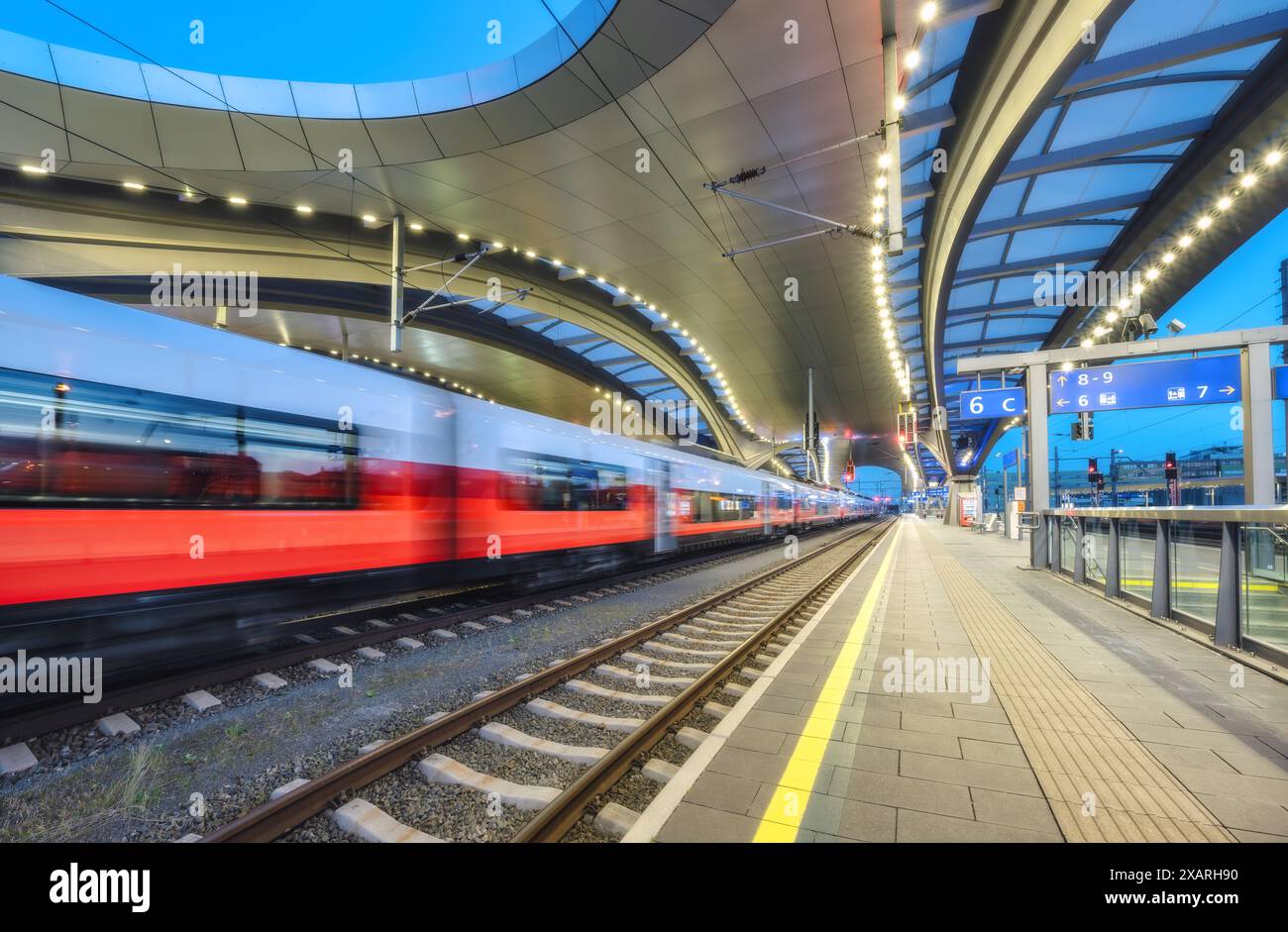 High-speed train at the illuminated railway station at night Stock ...