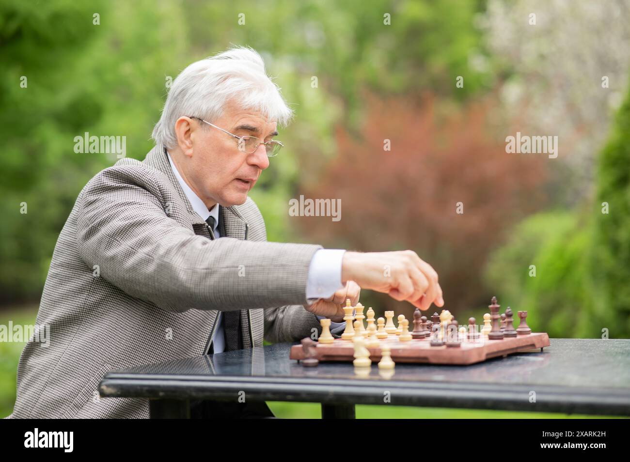 Elderly Caucasian man playing chess outdoors Stock Photo - Alamy