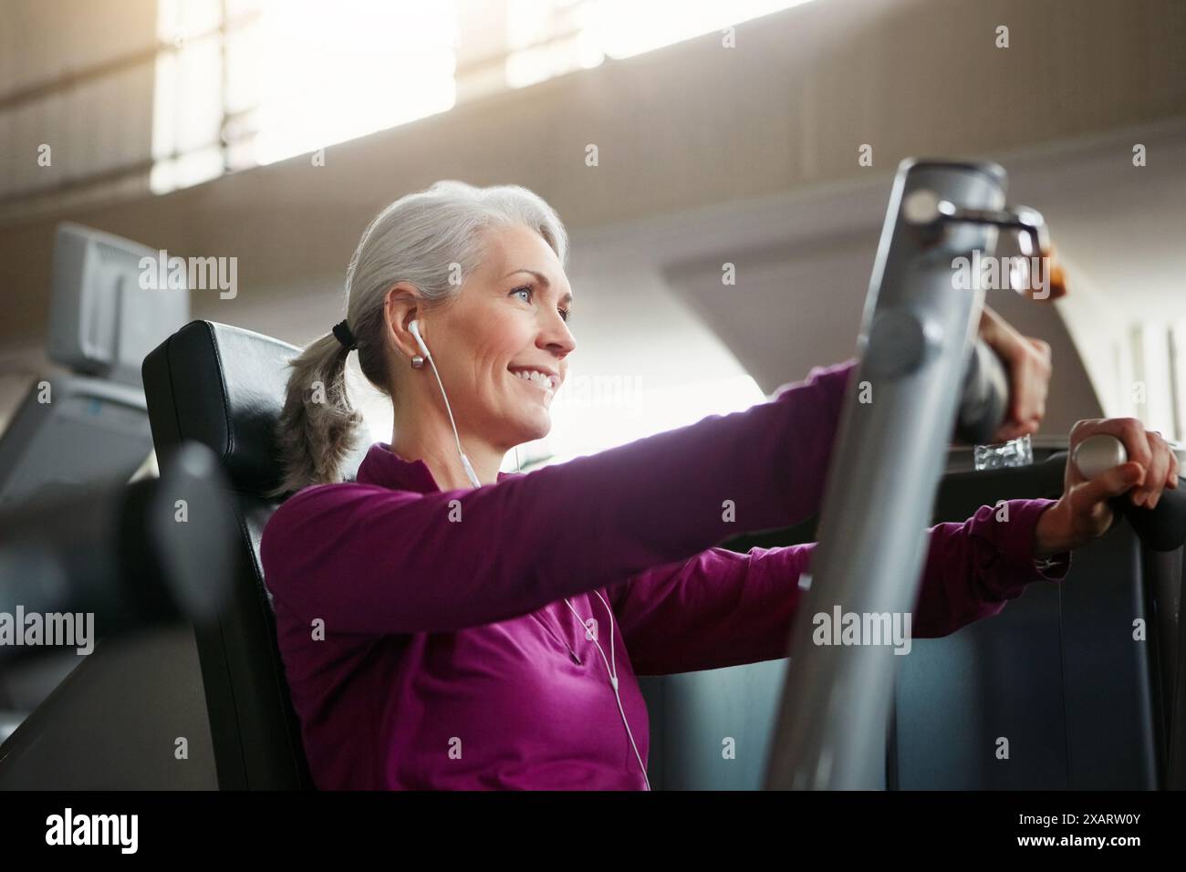 Mature, happy woman and chest press with machine for workout, fitness ...