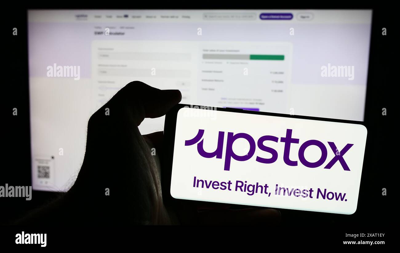 Person holding mobile phone with logo of trading platform company ...