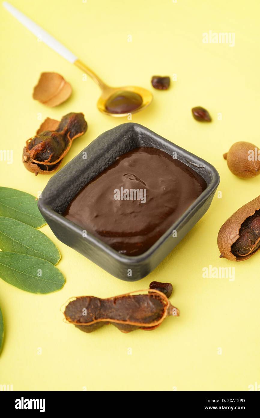Bowl with tasty tamarind jam with fruits on yellow background Stock ...