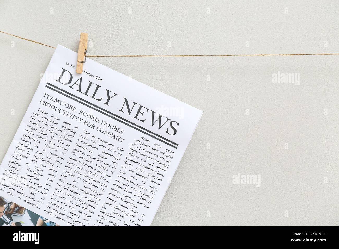Newspaper hanging on rope against white background Stock Photo - Alamy