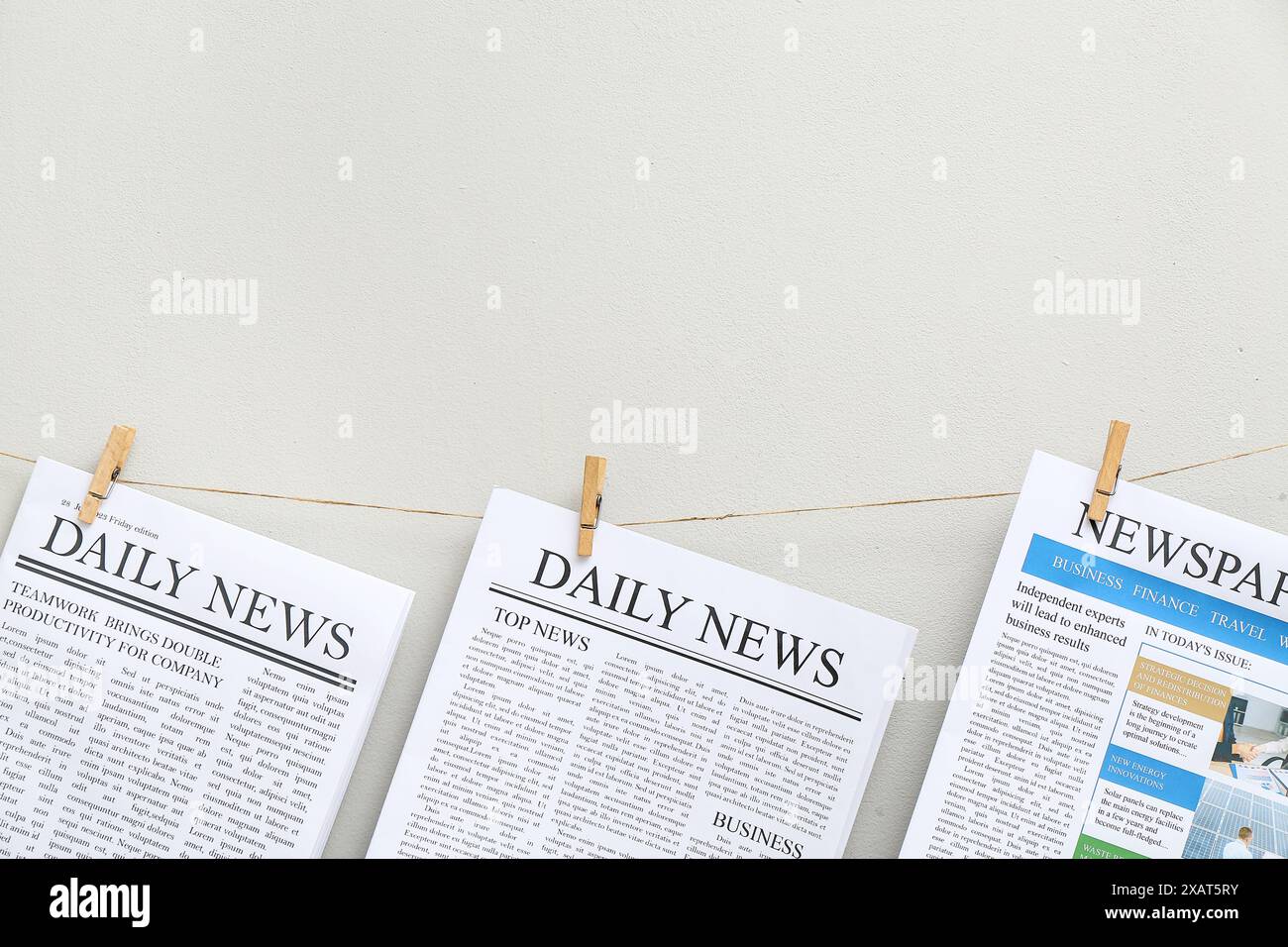 Newspapers hanging on rope against white background Stock Photo - Alamy