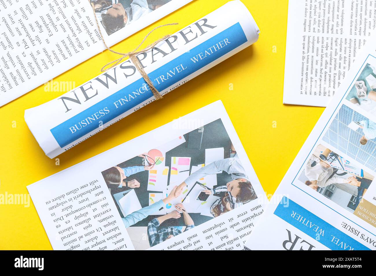 Different newspapers on yellow background Stock Photo - Alamy