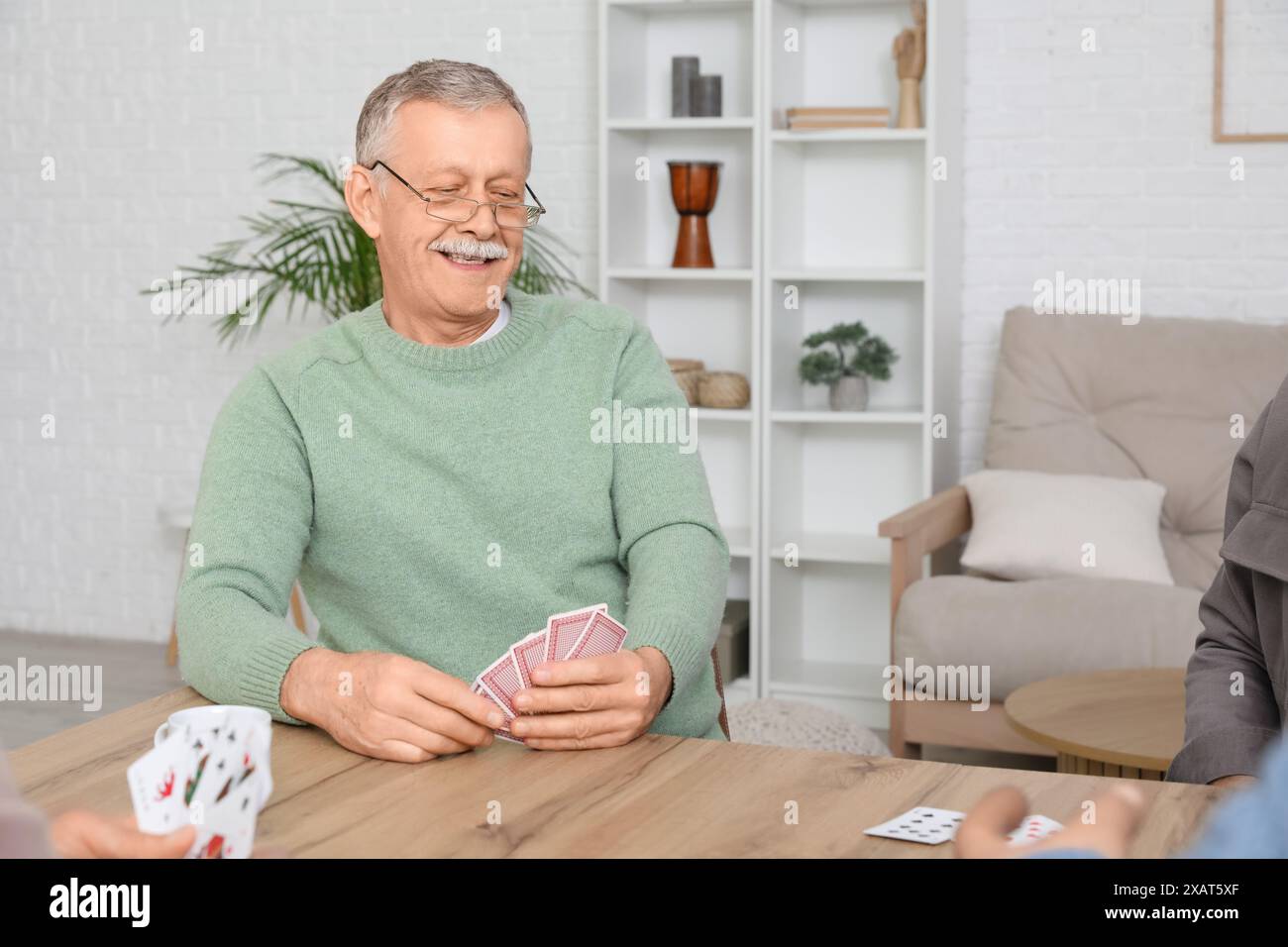 Elderly man playing cards at home Stock Photo - Alamy