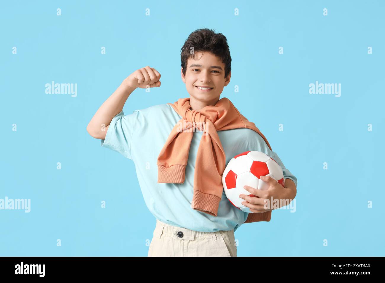 Teenage boy with soccer ball showing muscles on blue background Stock ...
