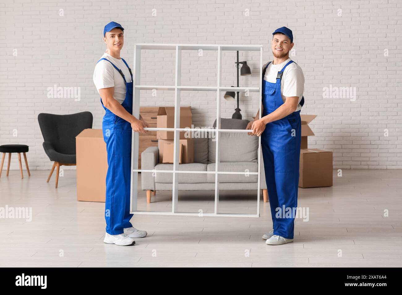 Loaders carrying shelving unit at home on moving day Stock Photo - Alamy