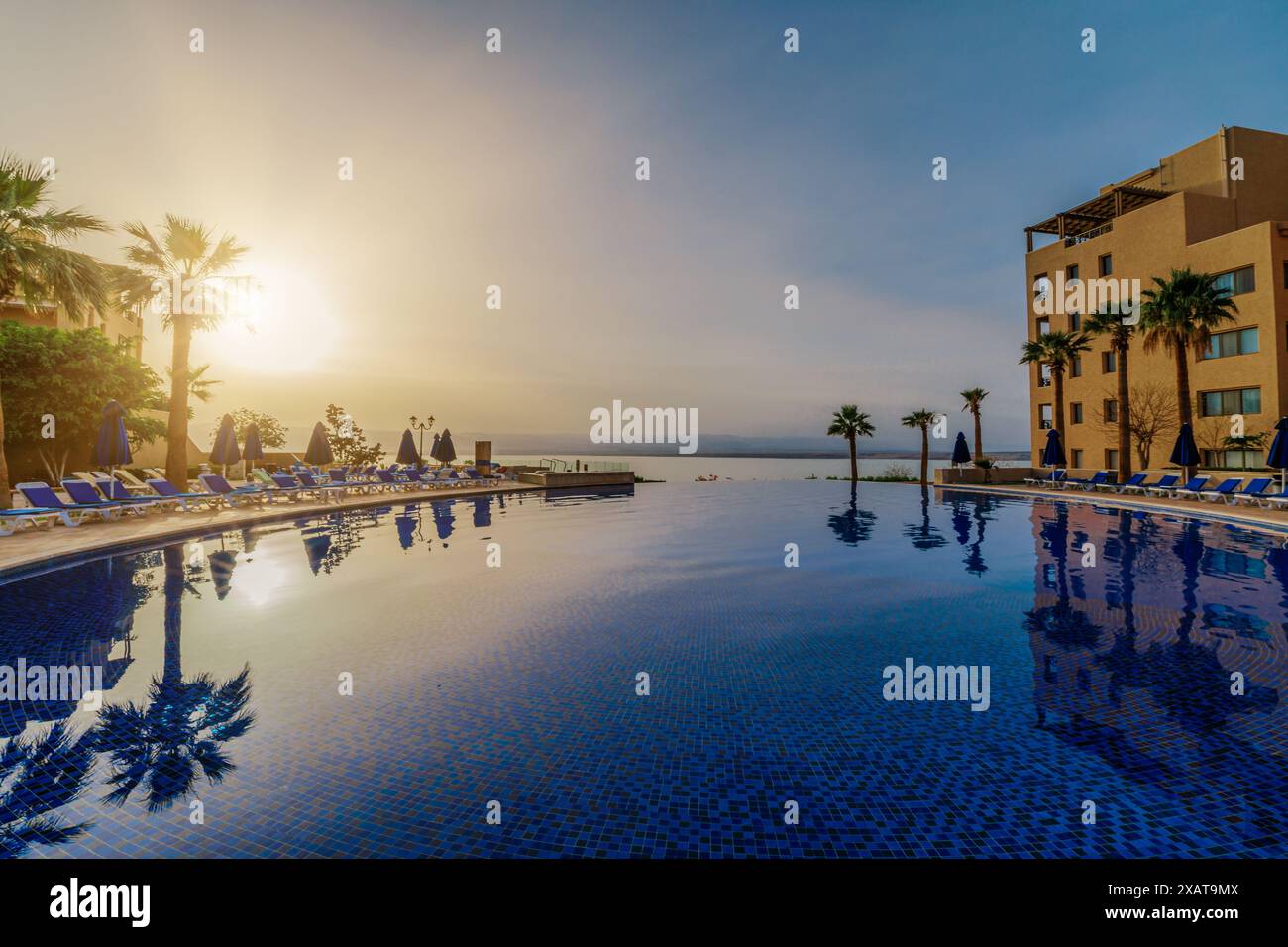 a tranquil moment by an infinity pool on Dead Sea lake view as the sun ...