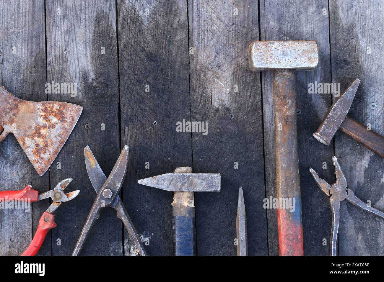 Old work tools on a wooden plank surface, top view. Hammers ...