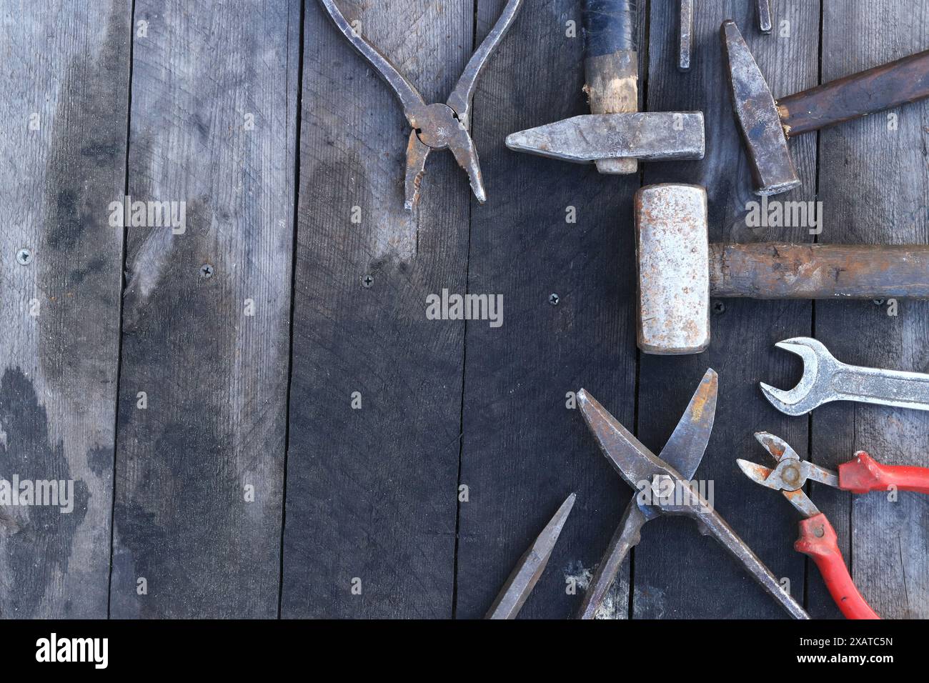 Old work tools on a wooden plank surface, top view. Hammers ...