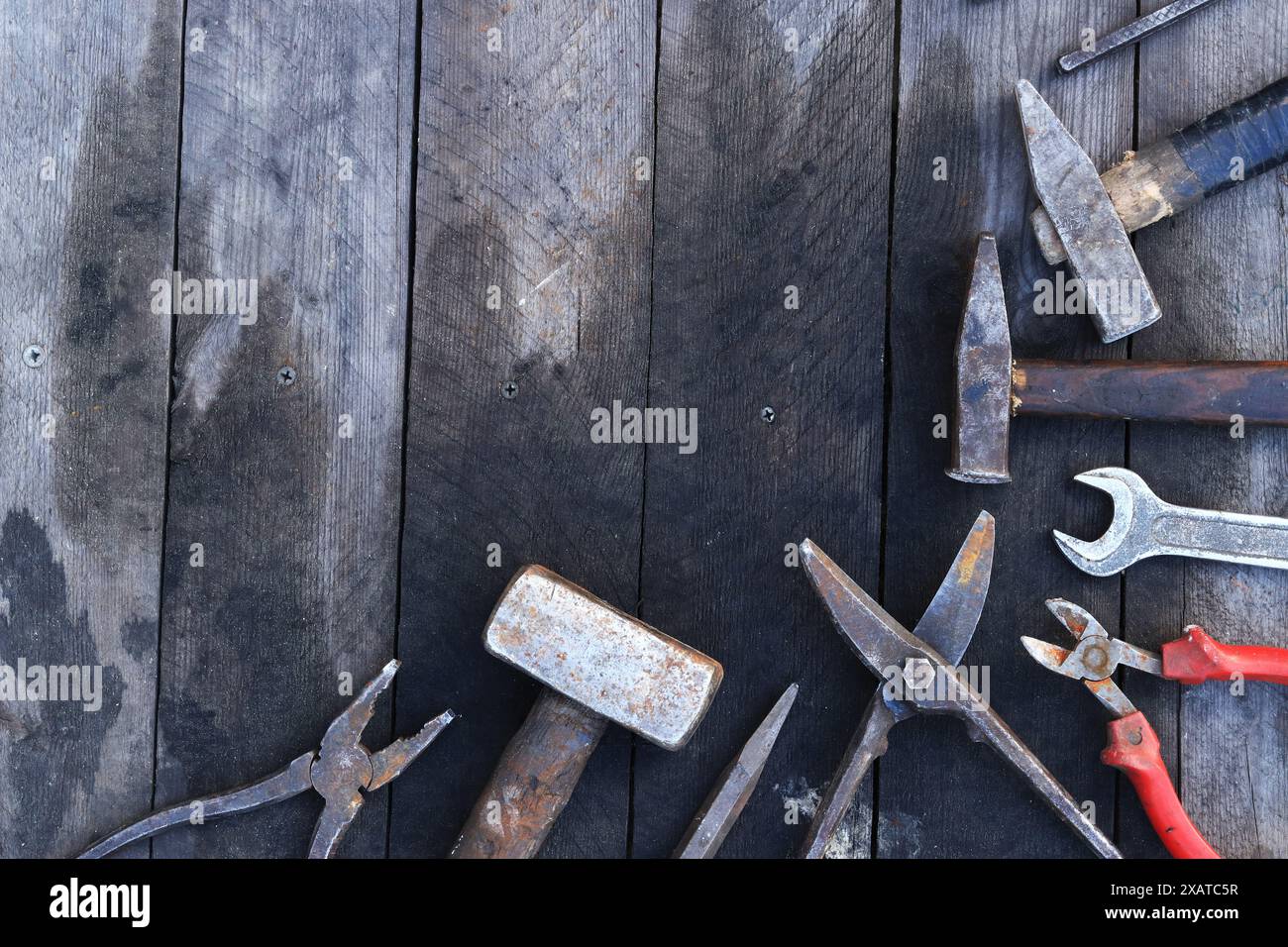 Old work tools on a wooden plank surface, top view. Hammers ...