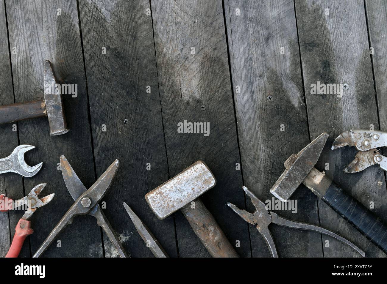 Old work tools on a wooden plank surface, top view. Hammers ...