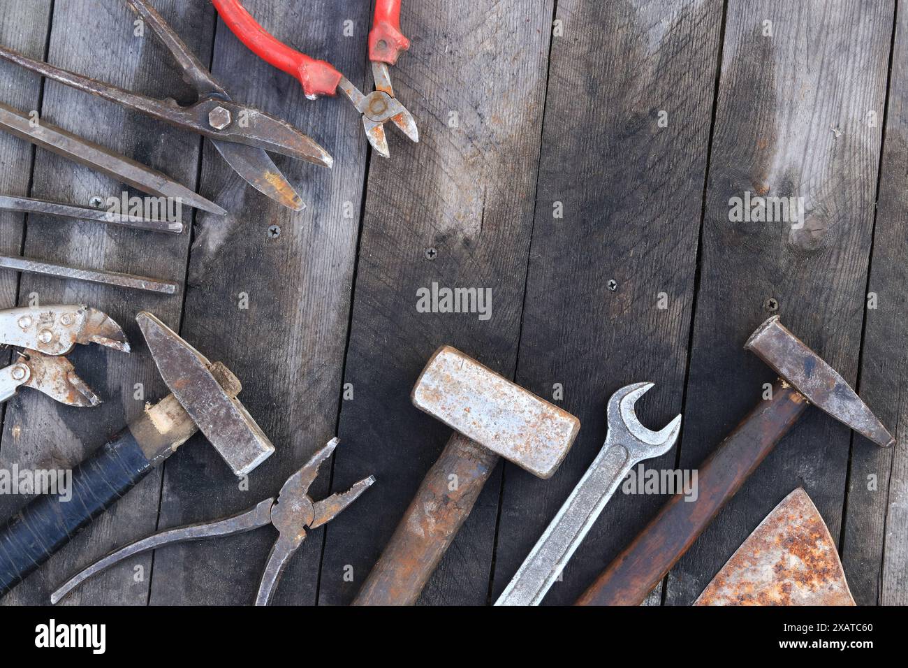 Old work tools on a wooden plank surface, top view. Hammers ...