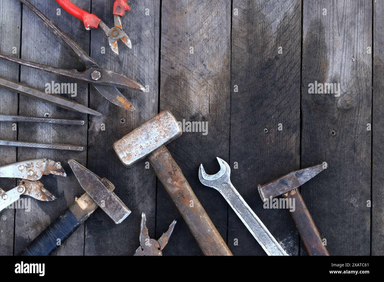Old work tools on a wooden plank surface, top view. Hammers ...