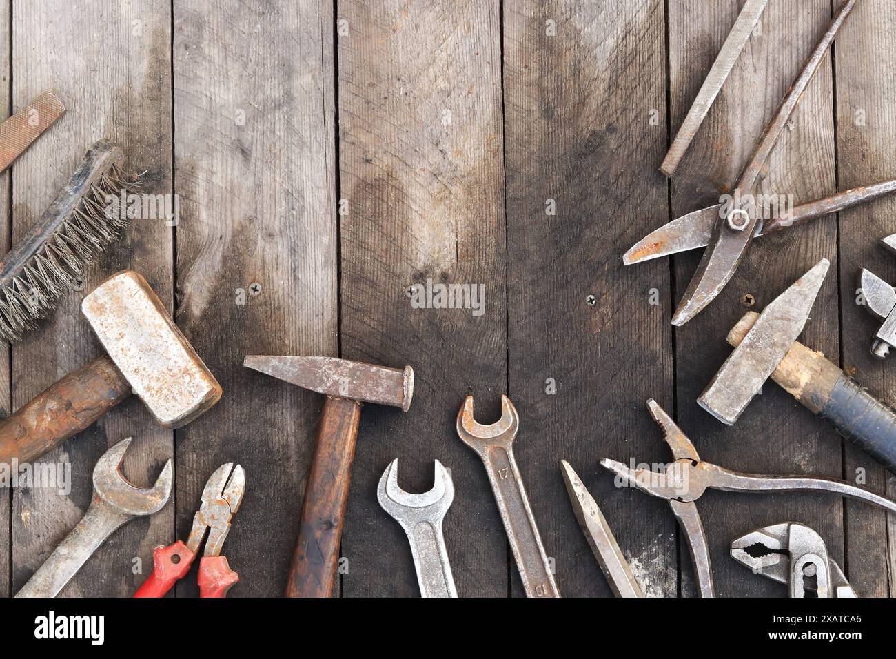 Old work tools on a plank wooden background, top view. Hammers, flat ...