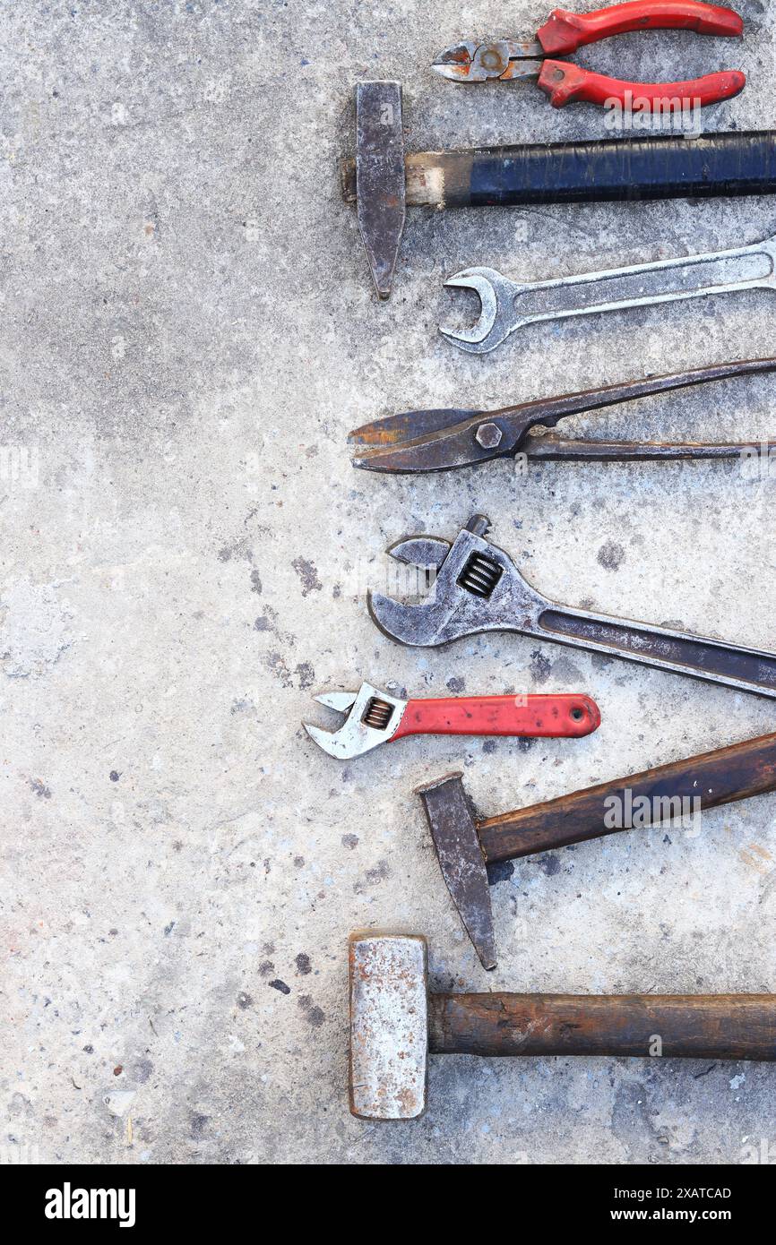 Old working tools on a concrete surface, top view. Hammers ...