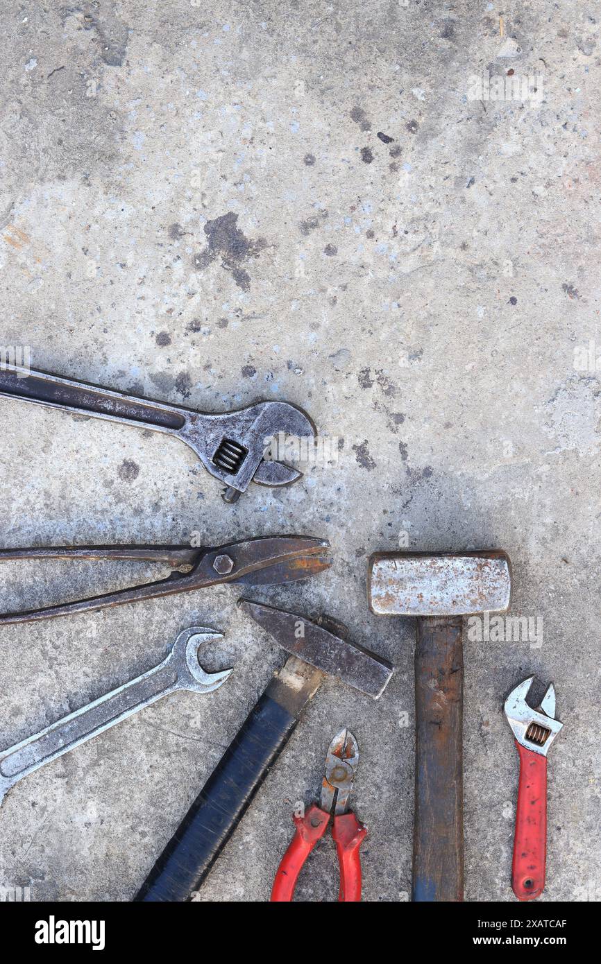 Old working tools on a concrete surface, top view. Hammers ...