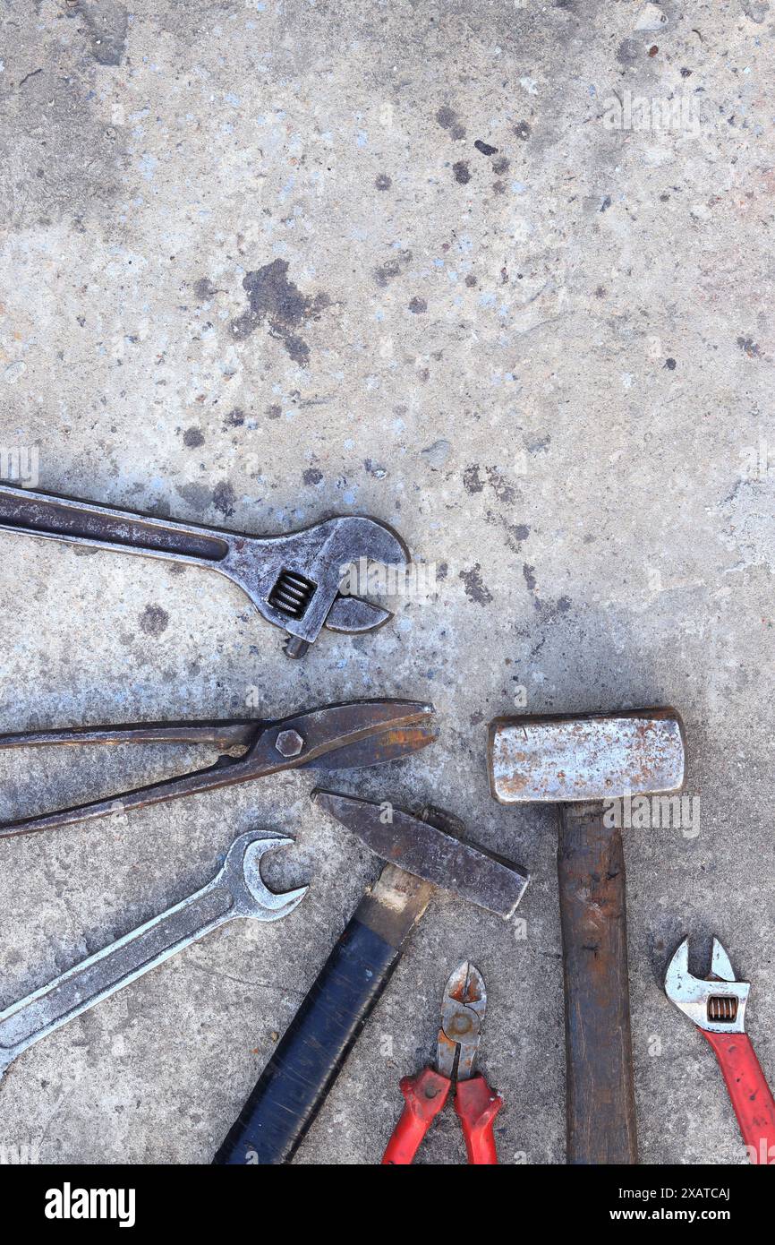 Old working tools on a concrete surface, top view. Hammers ...