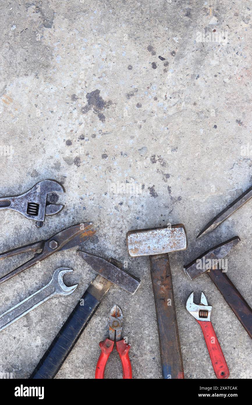 Old working tools on a concrete surface, top view. Hammers ...