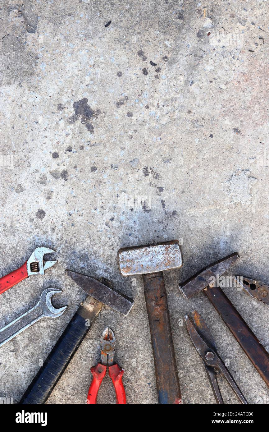 Old working tools on a concrete surface, top view. Hammers ...