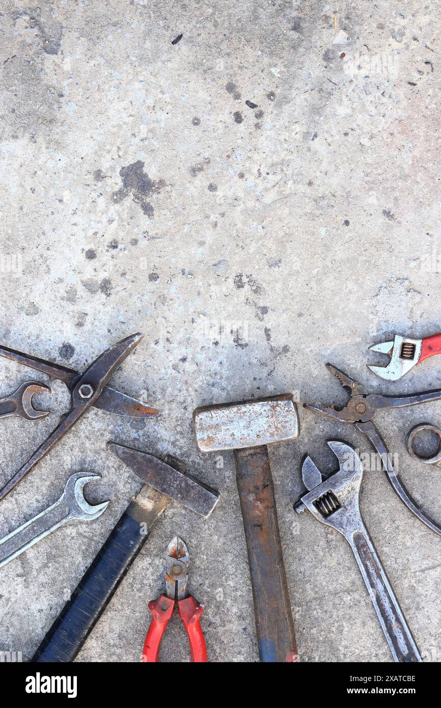 Old working tools on a concrete surface, top view. Hammers ...