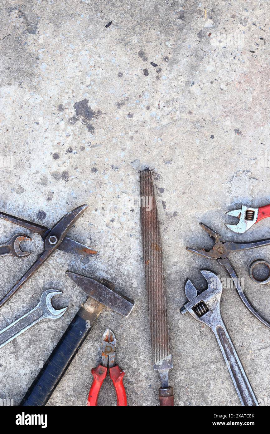 Old working tools on a concrete surface, top view. Hammers, flat file ...
