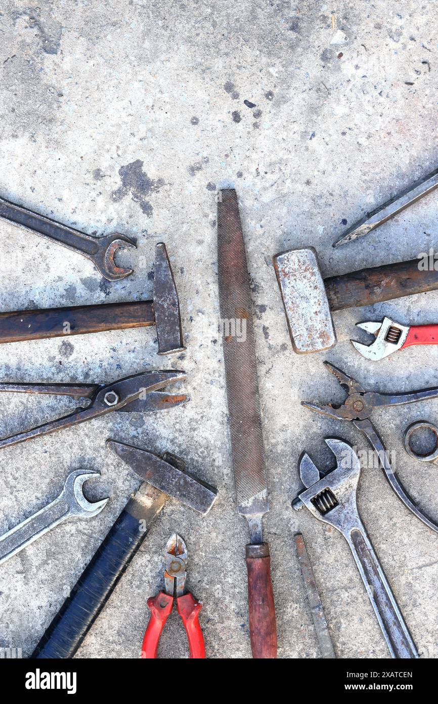 Old working tools on a concrete surface, top view. Hammers, flat file ...