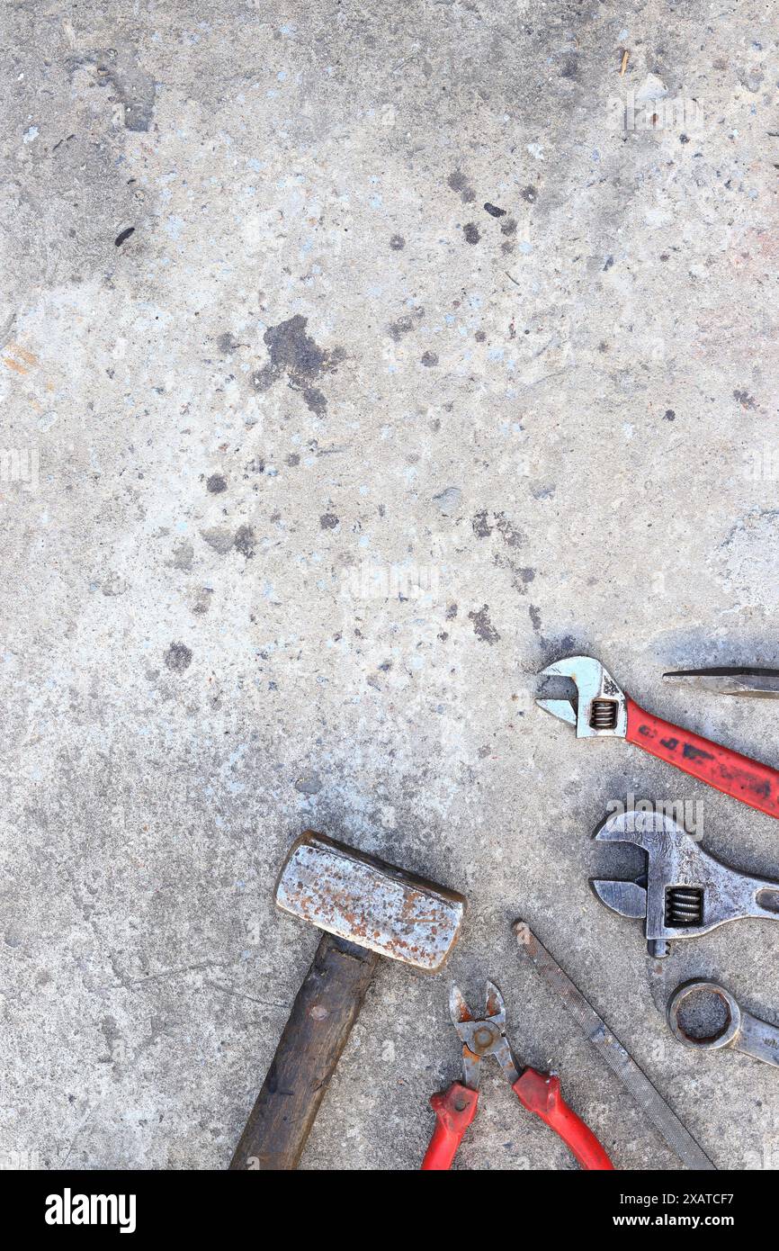 Old working tools on a concrete surface, top view. Hammer, side cutters ...