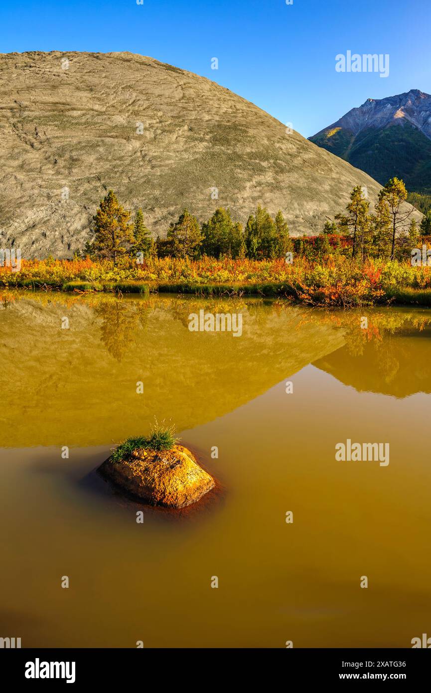 A pond full of runoff water at the base of the large tailings pile from ...