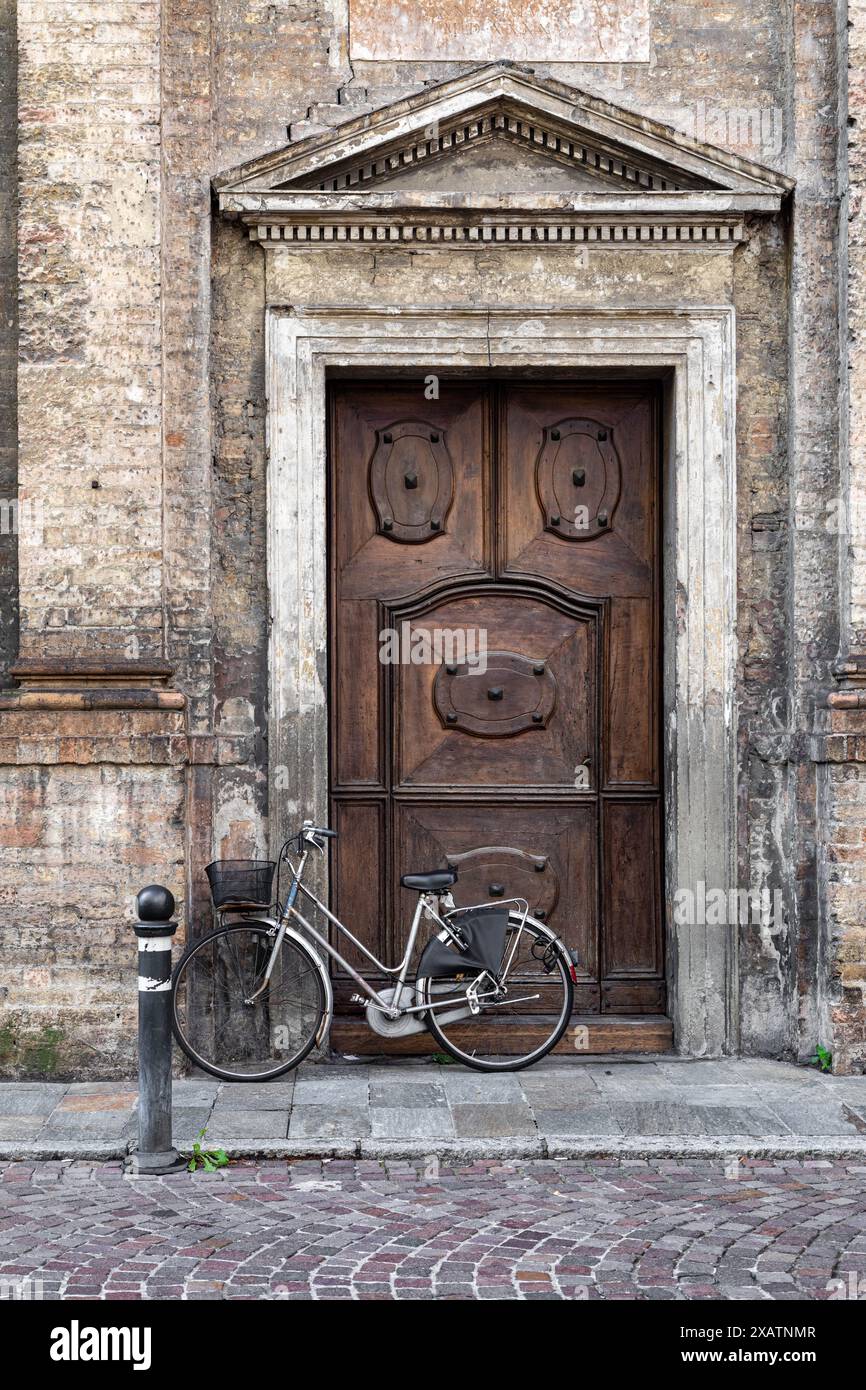 Bicycle proped up beside an old wooden door, black and white image ...