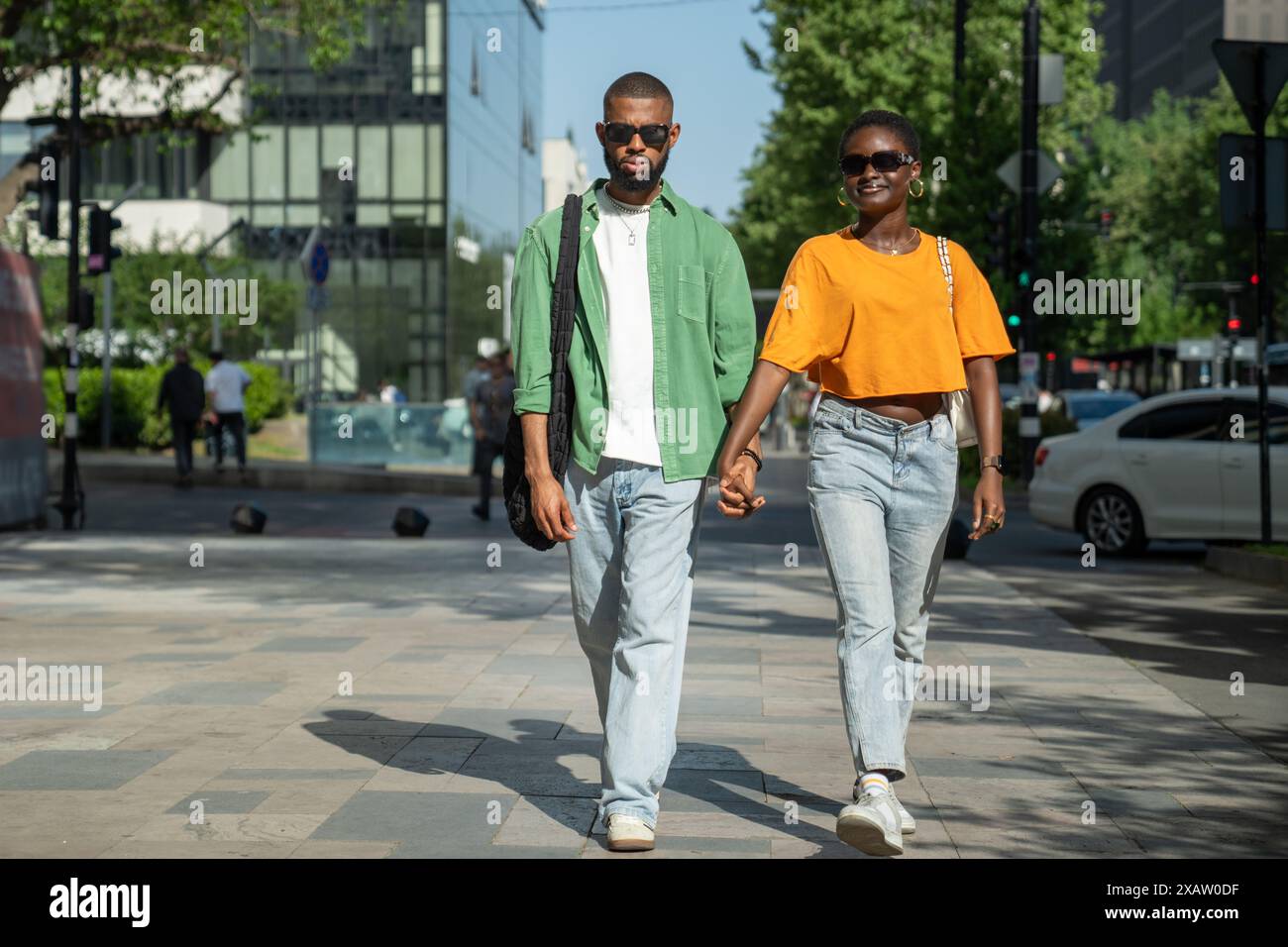 Serious boyfriend, cheerful girlfriend on date. Black couple holding ...