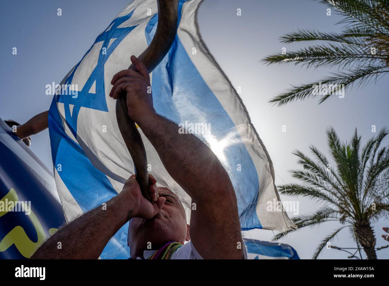 An Israeli man seen blowing the Jewish Shofar with the Israeli flag in ...