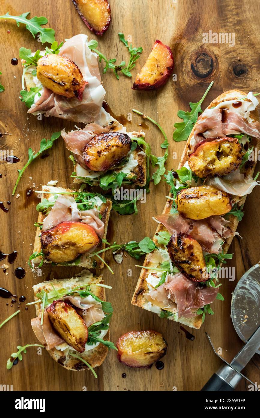 Toasted peach and prosciutto baguette sandwich topped with arugula ...