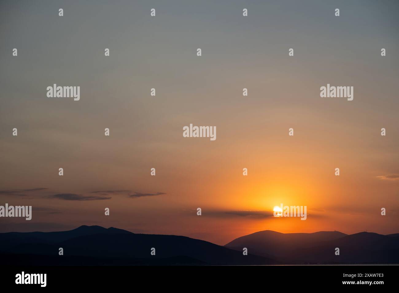 Sunset behind mountain silhouette over the sea on colorful sky ...