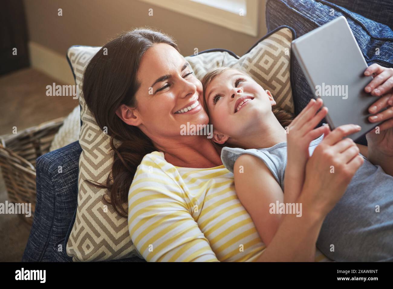 Tablet, mother and girl on couch with internet for reading ebook ...