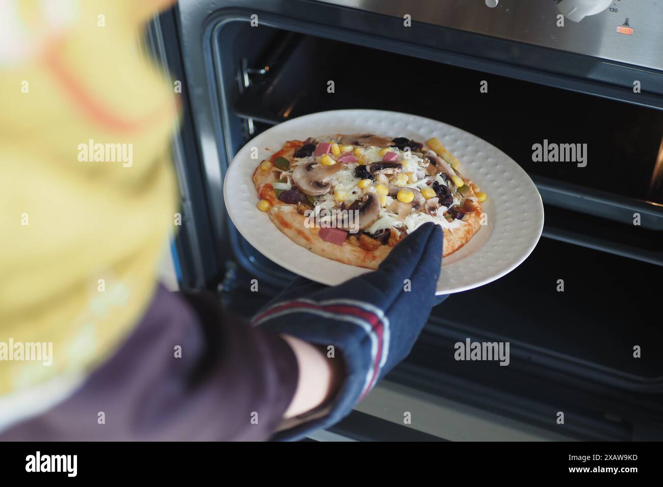 When baking a homemade pizza in the oven, ensure safety by wearing a ...
