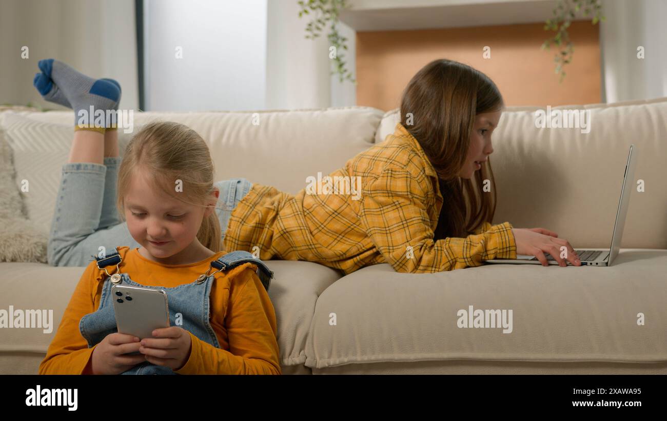 Carefree Caucasian children little girls kids daughters using mobile ...