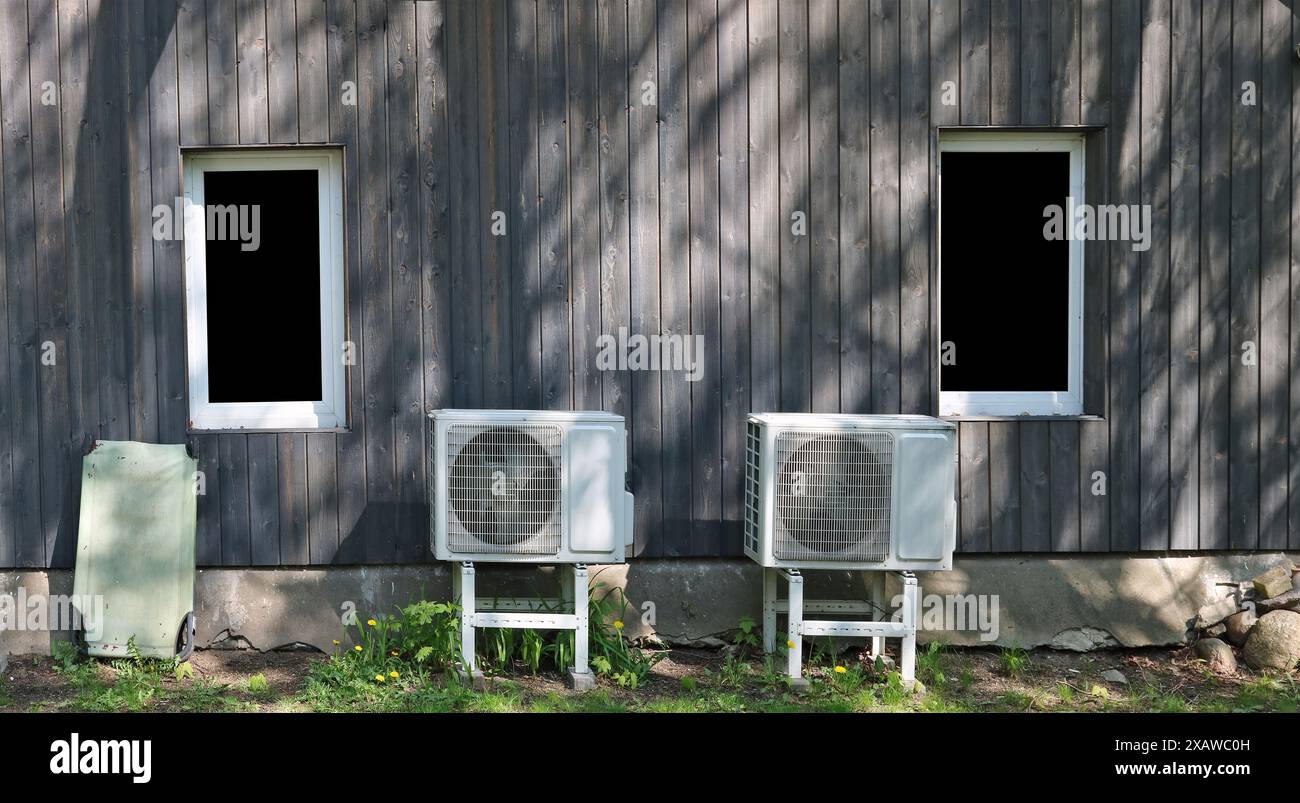 Powerful air conditioners installed on the wall of a wooden rural barn ...