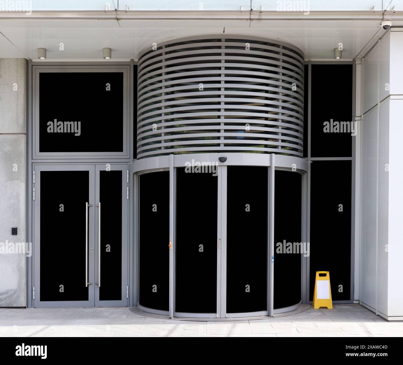 A round rrevolving door is installed at the entrance to a glass office ...