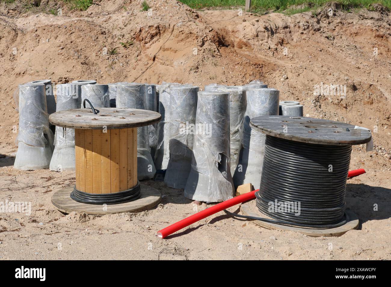 Reels with power electrical cable and concrete pillars on a ...