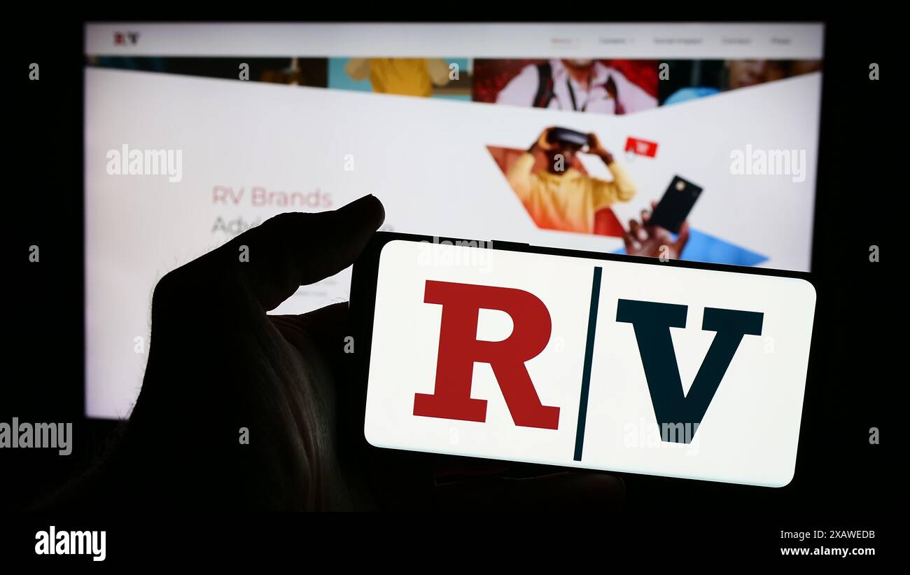 Person holding mobile phone with logo of American media company Red ...