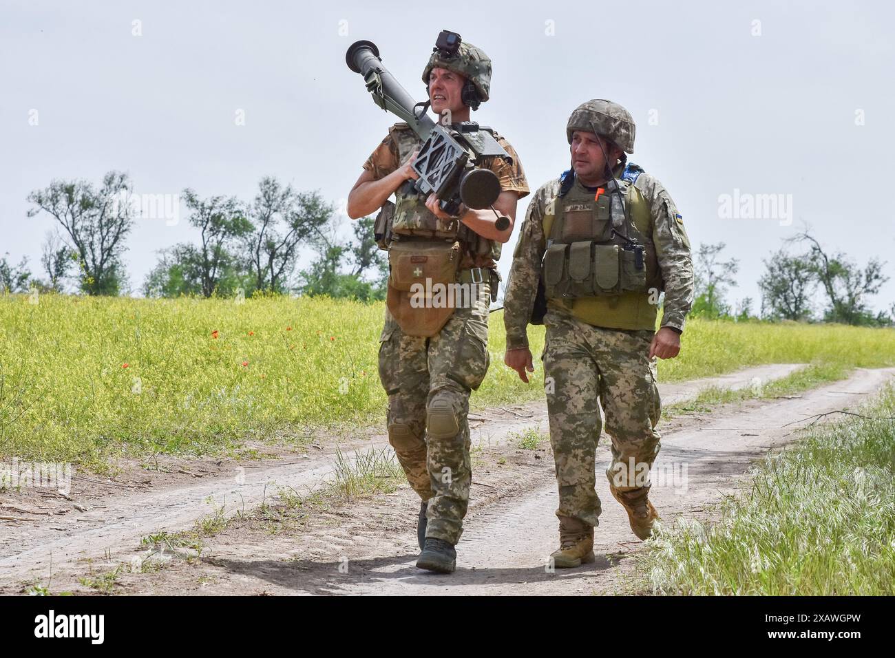 Ukrainian servicemen (air defence unit) walk down the road with a US ...