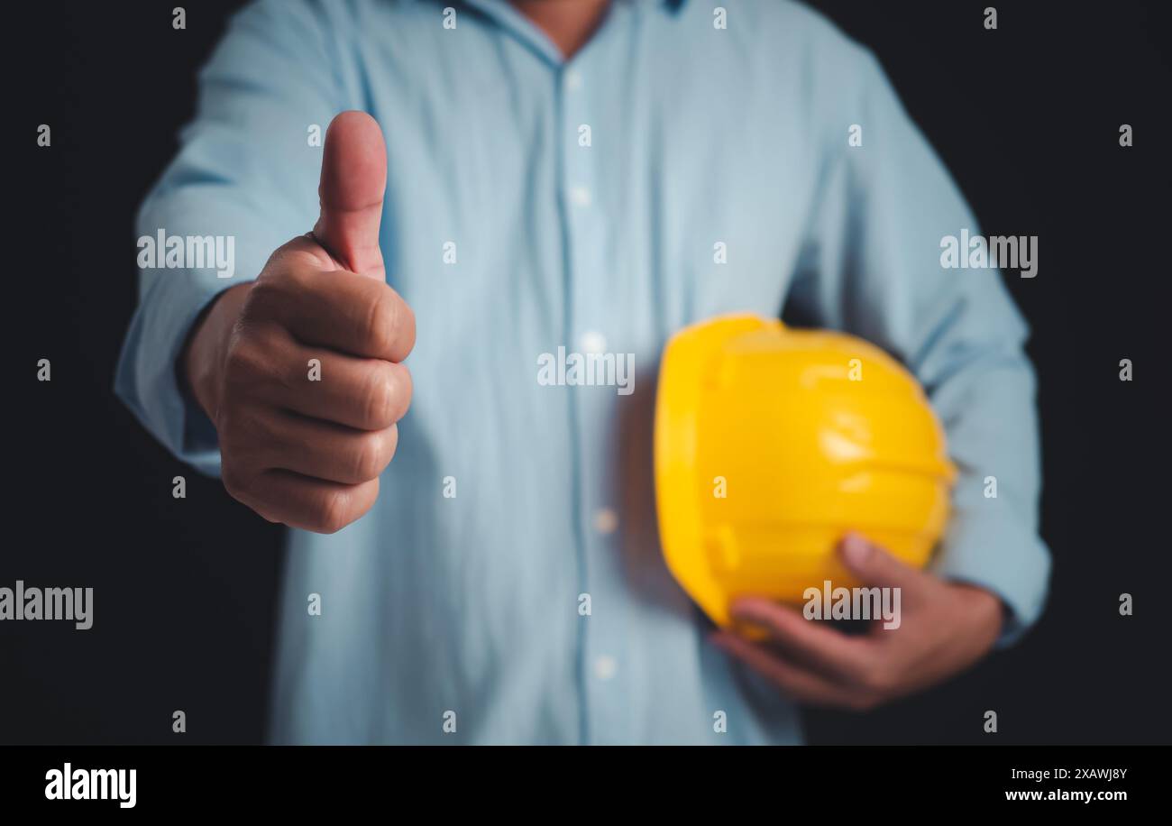 Civil engineer architect standing holding a safety helmet on dark ...