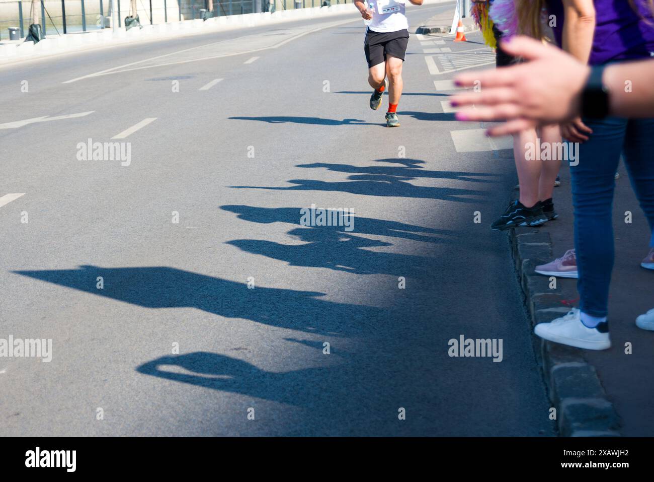 Shadow of fan group cheering marathon runner Stock Photo - Alamy
