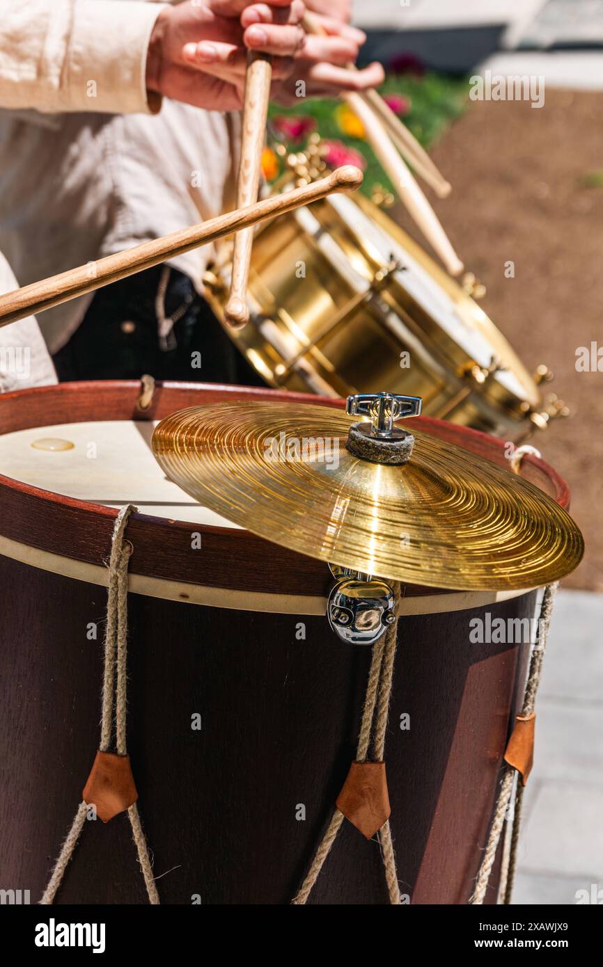 Detail of hands holding drumsticks playing timpani and drums with a ...
